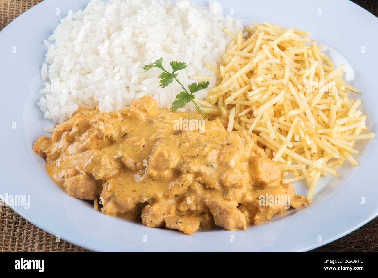 Food dish with chicken stroganoff and rice and chips Stock Photo - Alamy