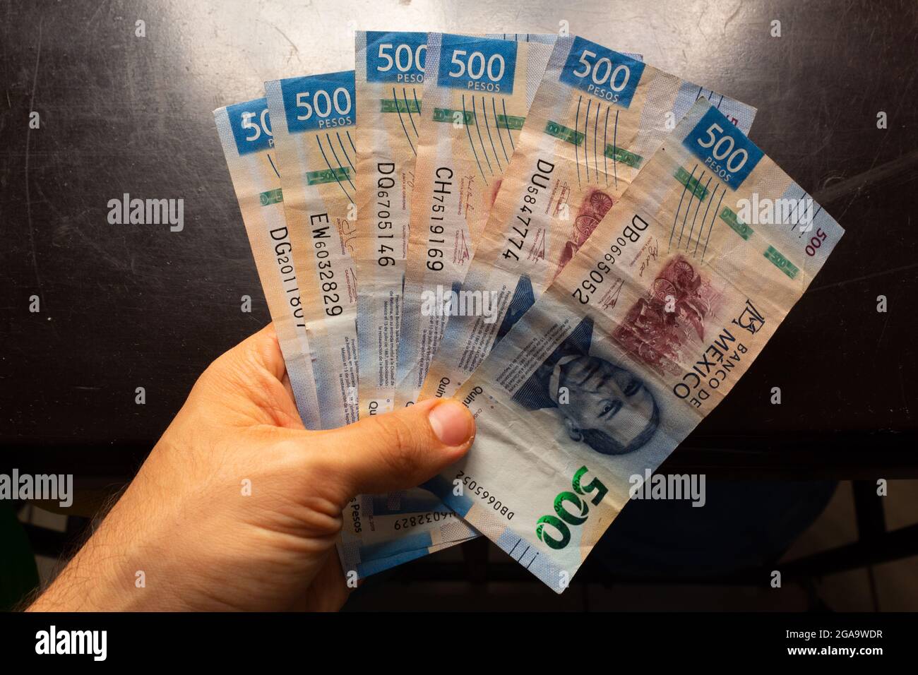 hand holding mexican money called pesos Stock Photo - Alamy