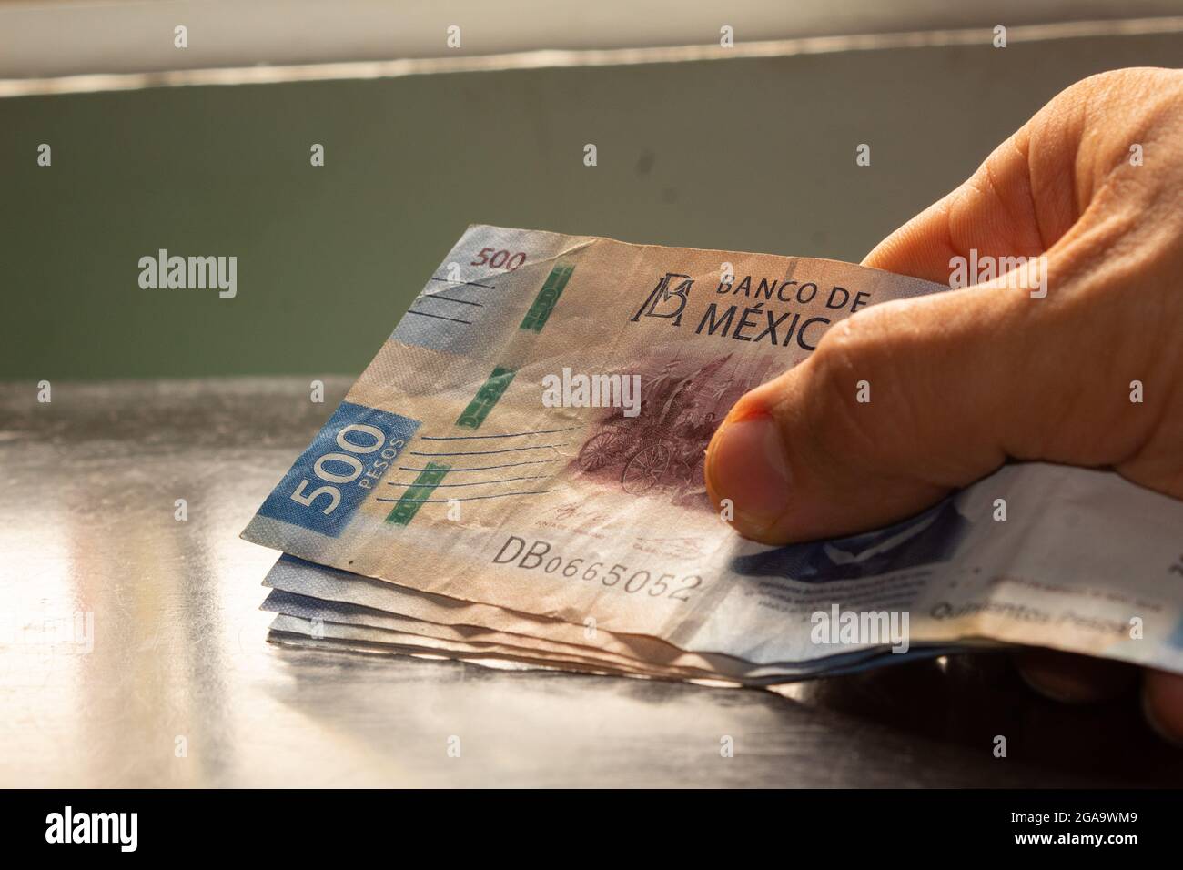 hand holding mexican money called pesos Stock Photo - Alamy