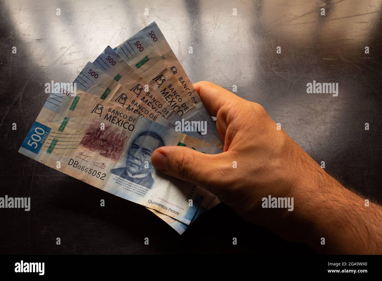 hand holding mexican money called pesos Stock Photo - Alamy