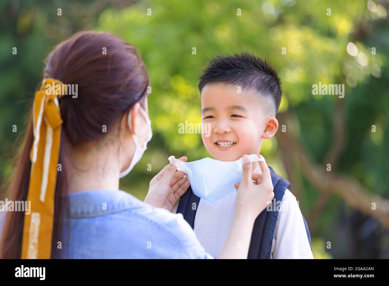 Mother help son wearing medical mask for protection Stock Photo - Alamy
