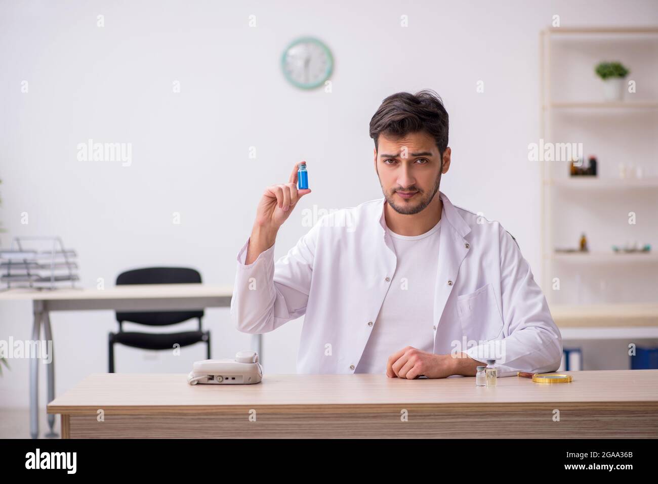 Young male chemist doctor holding vial at the lab Stock Photo - Alamy