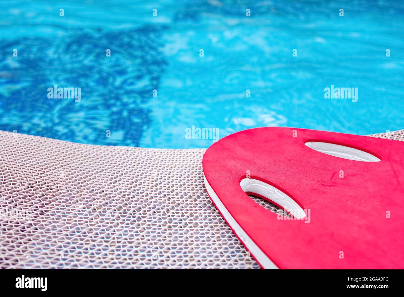 red floating pad near a swimming pool Stock Photo - Alamy