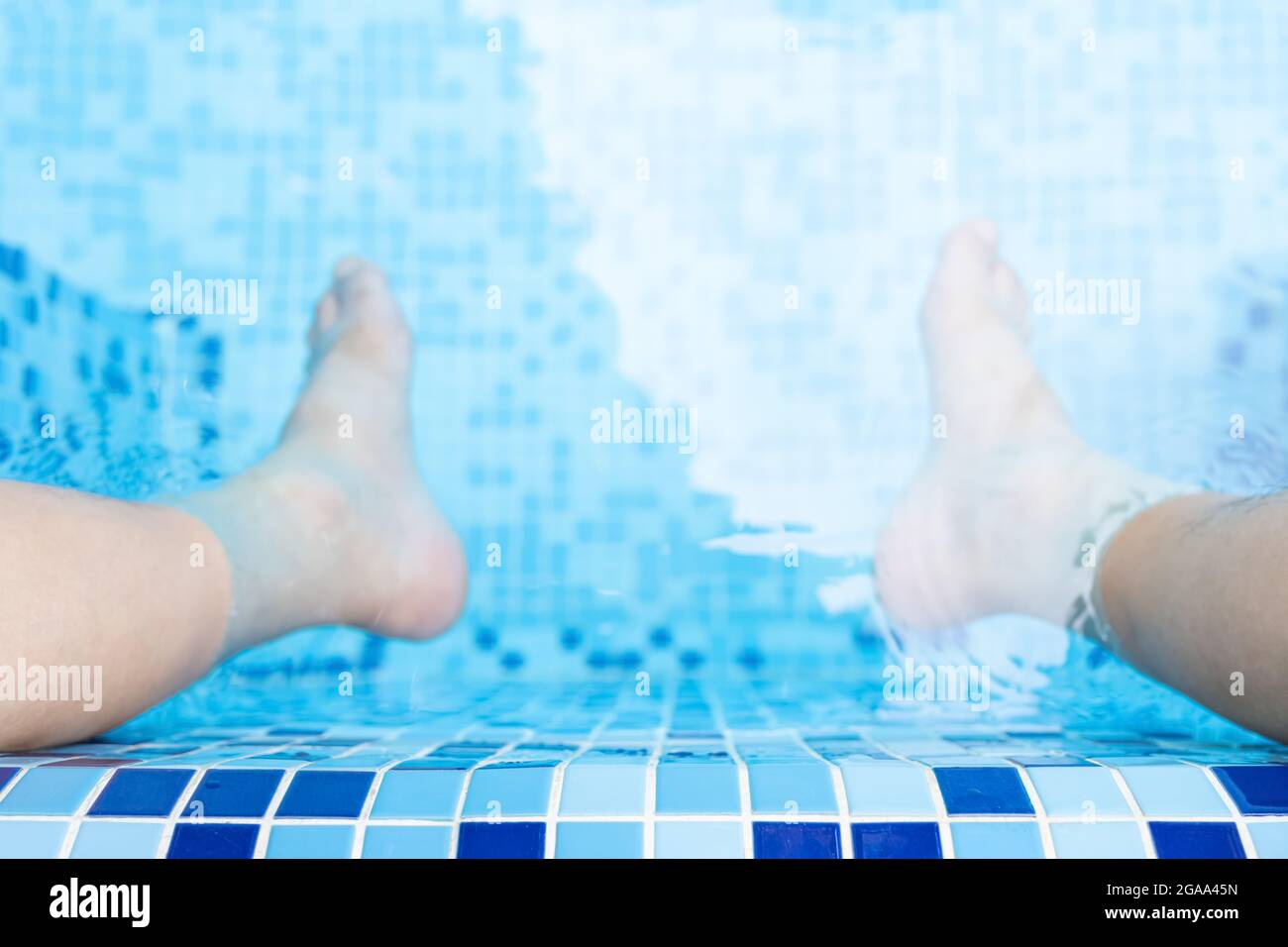 man sitting on the edge of a swimming pool Stock Photo - Alamy