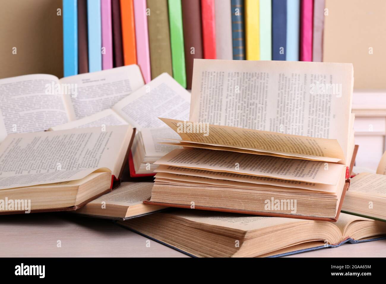 Opened books lying on bookshelf close-up Stock Photo - Alamy