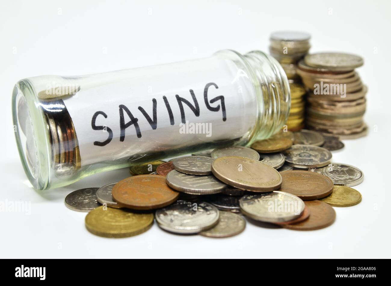 Saving lable in a glass jar with coins spilling out isolated on white ...