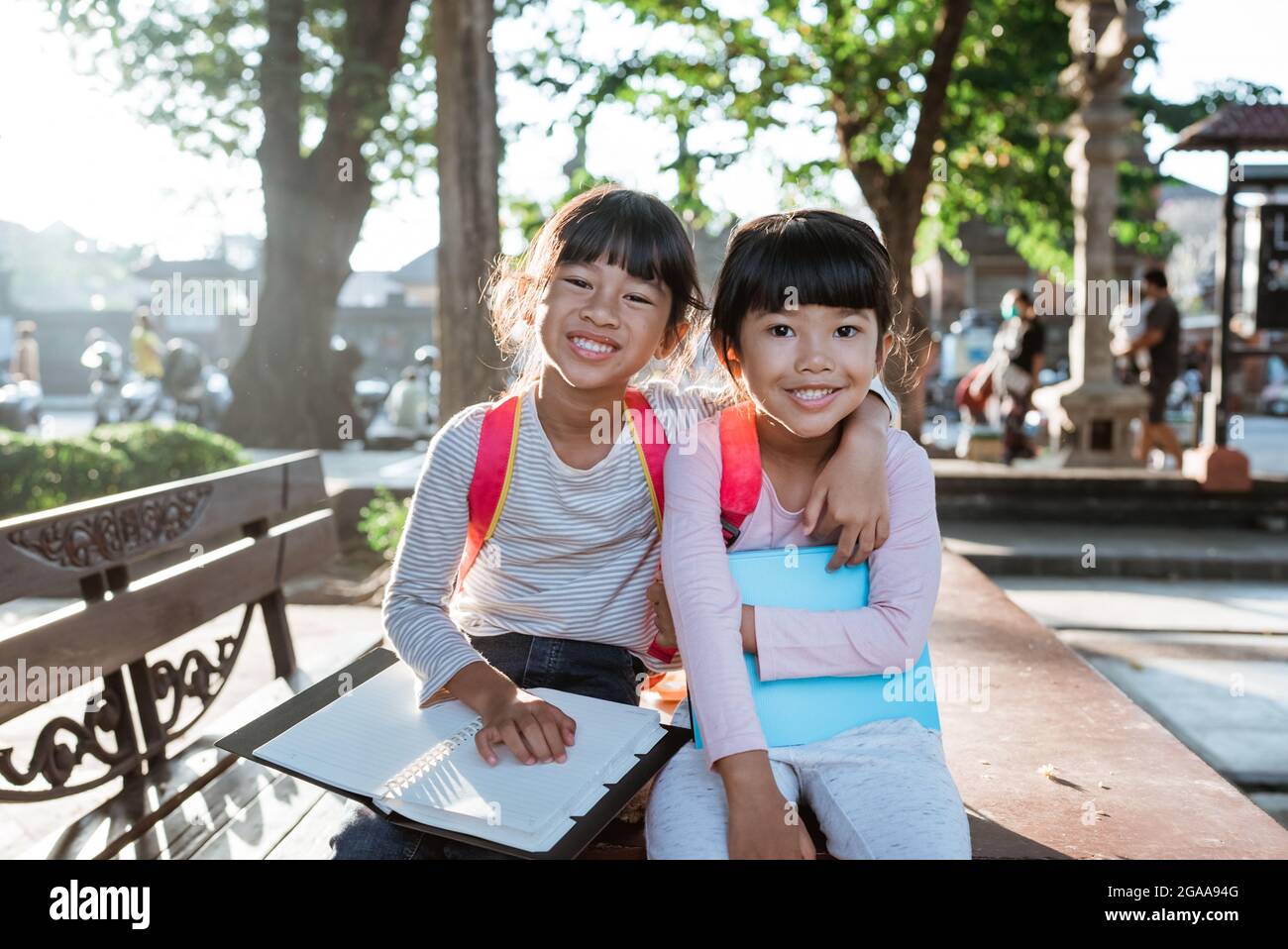 smiling two young little girl student holding book Stock Photo - Alamy