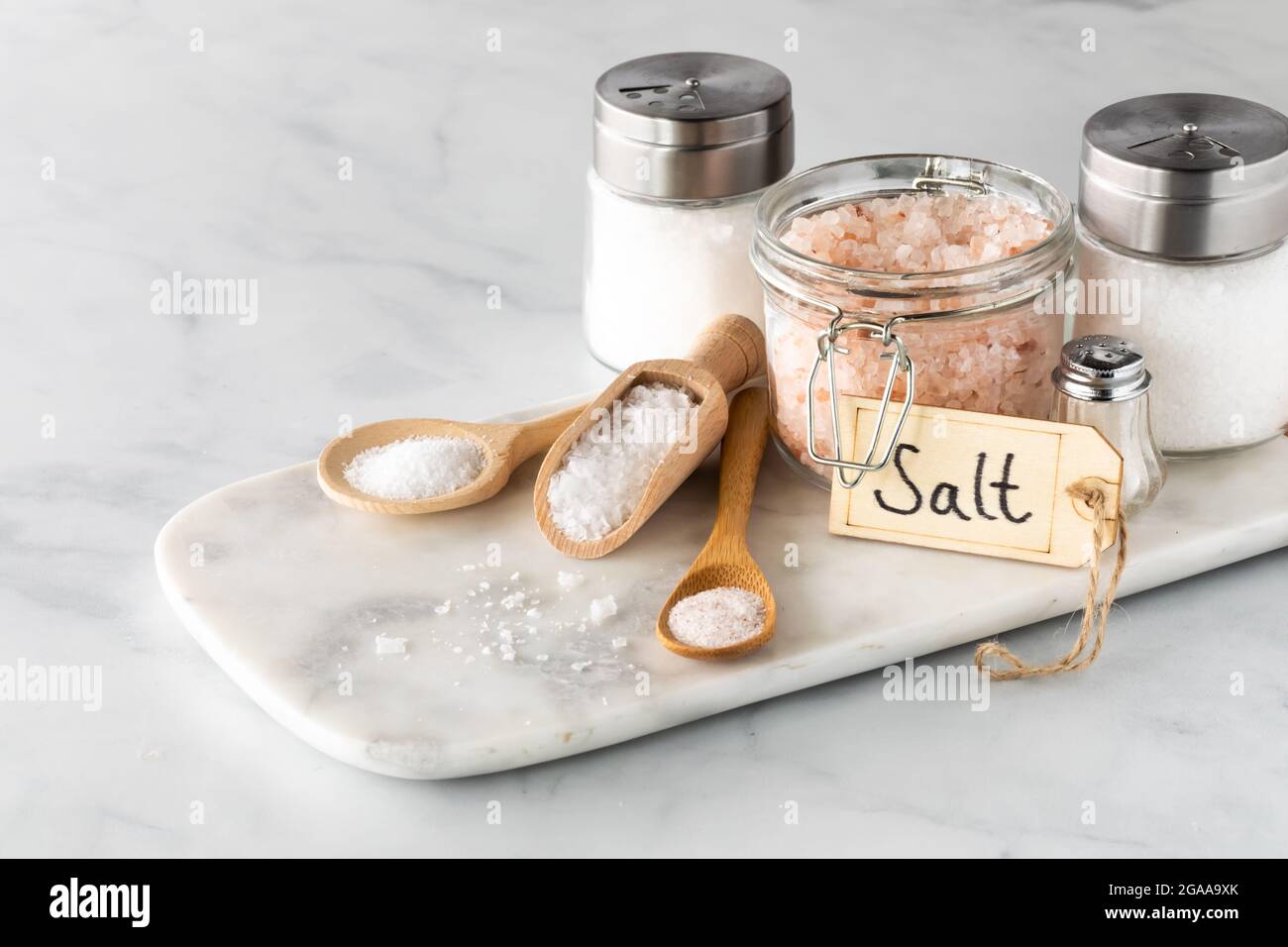 An arrangement of different types of salt on a marble slab including ...