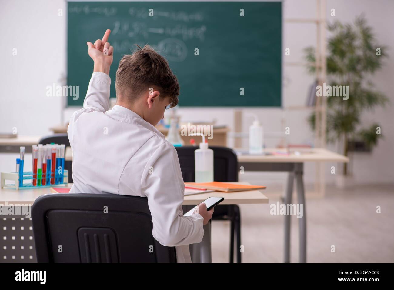 Male pupil studying chemistry in the classroom Stock Photo - Alamy