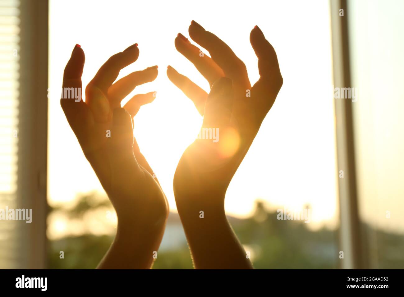 Female hands over sunset sky background Stock Photo - Alamy