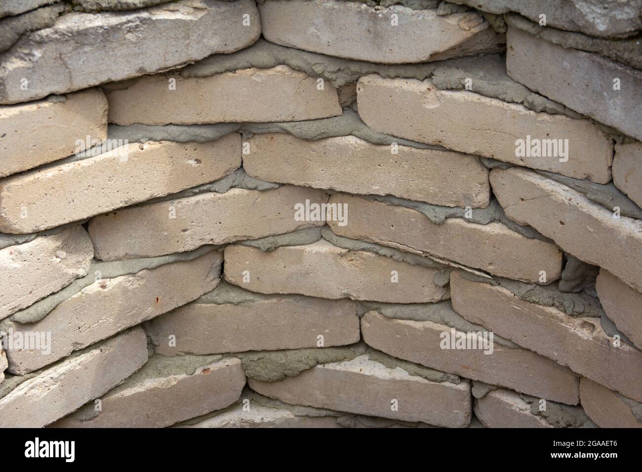 Brickwork in a semicircle of white, gray bricks. The wall of an old ...