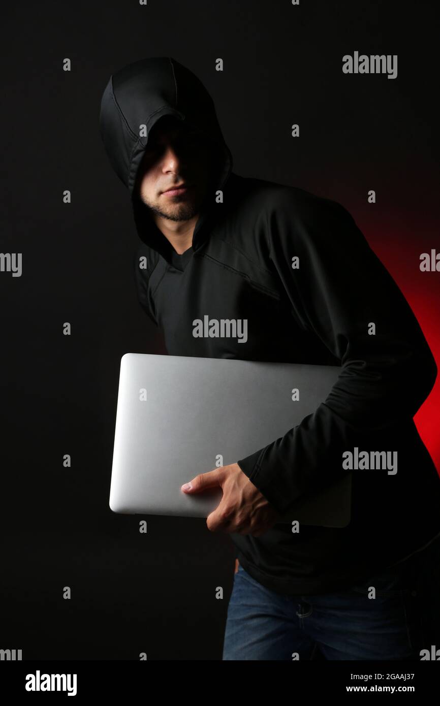 Hacker with computer and laptop on colorful dark background Stock Photo ...