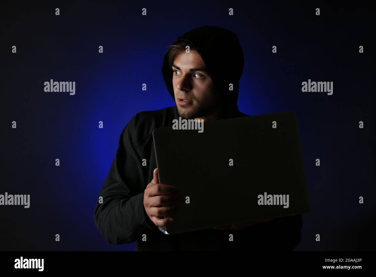 Hacker with computer and laptop on colorful dark background Stock Photo ...