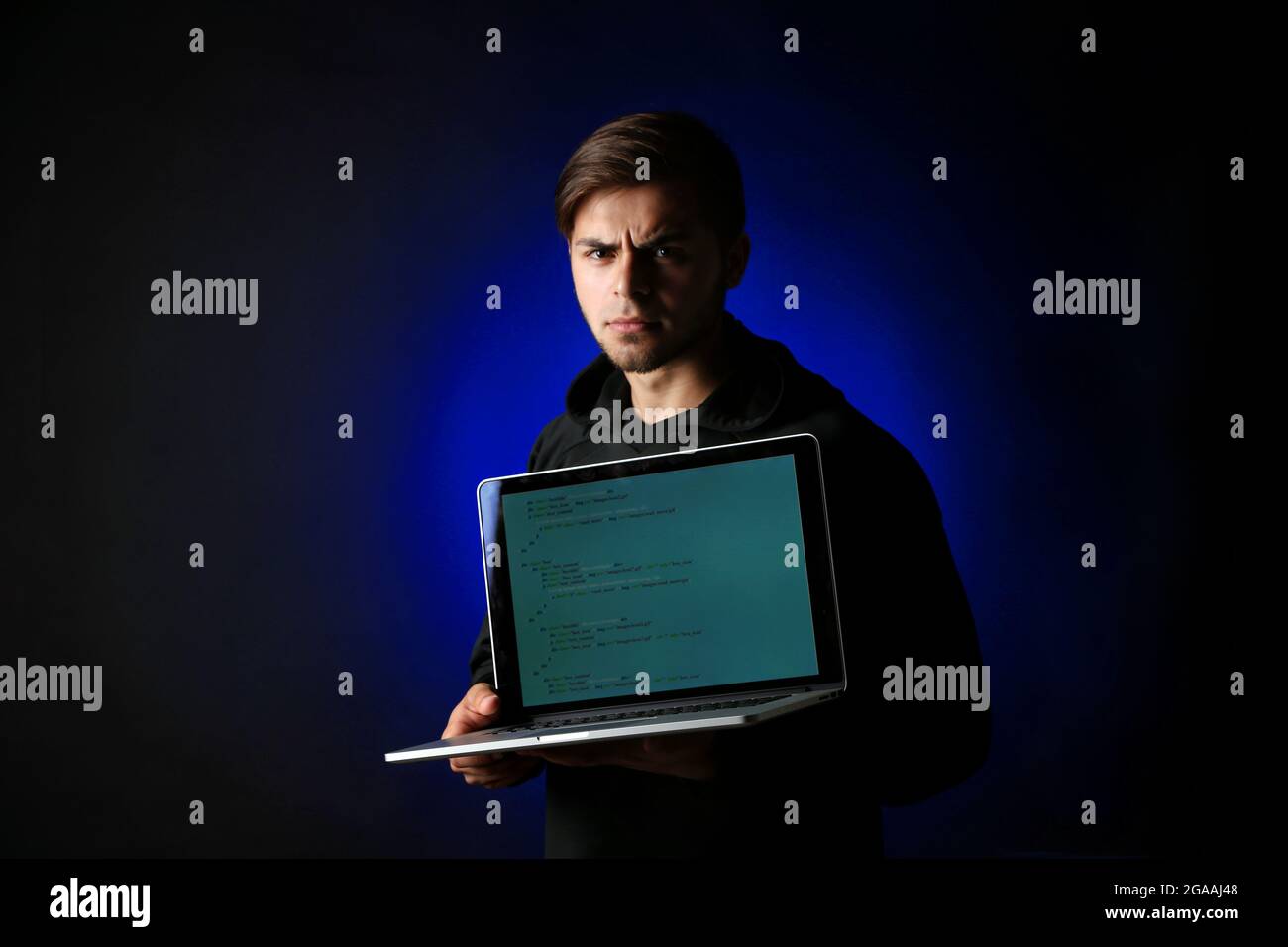 Hacker with computer and laptop on colorful dark background Stock Photo ...