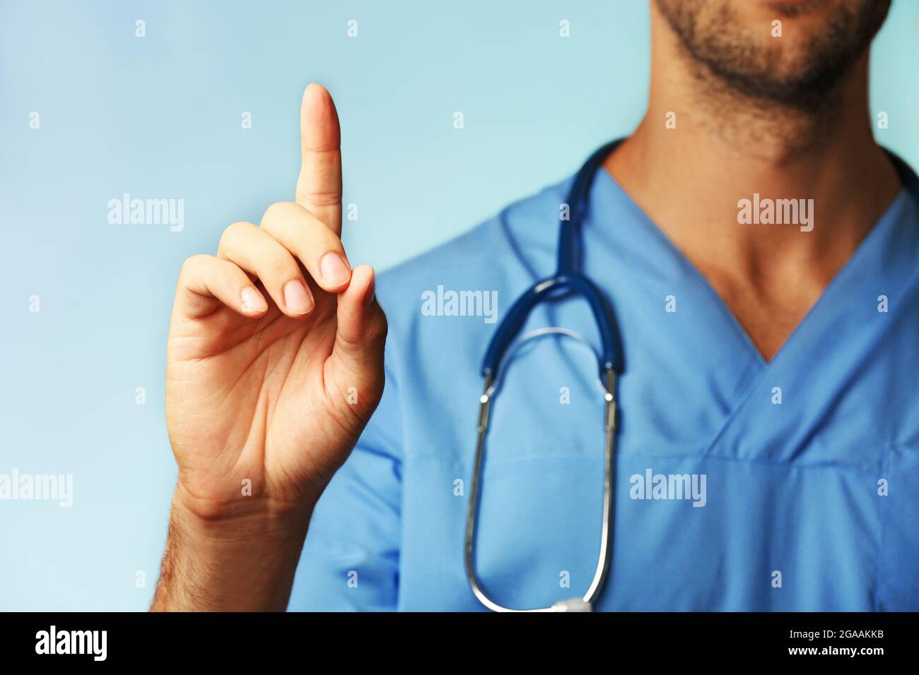 Doctor pointing his finger up on grey background Stock Photo - Alamy