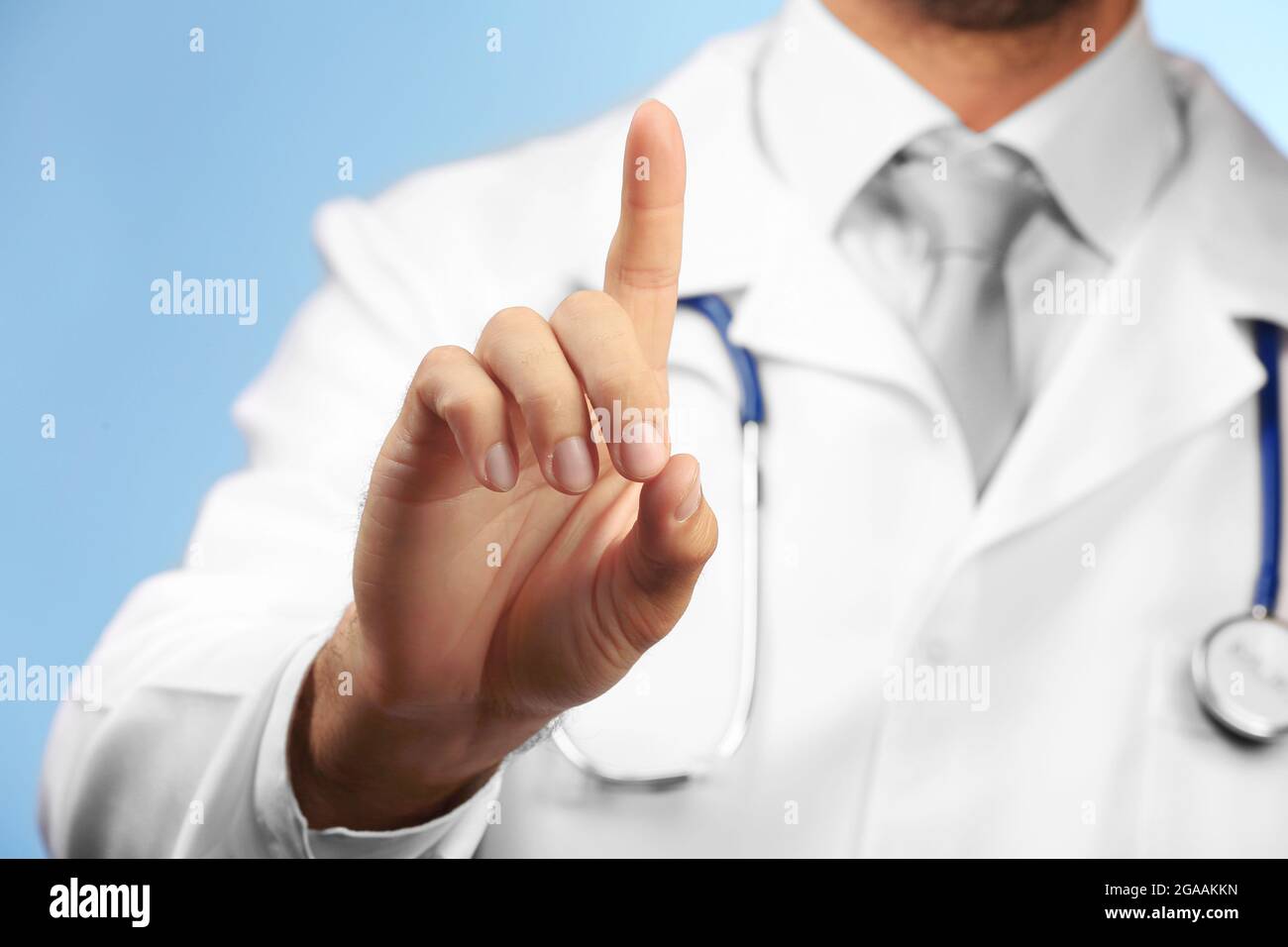 Doctor pointing his finger up on blue background Stock Photo - Alamy