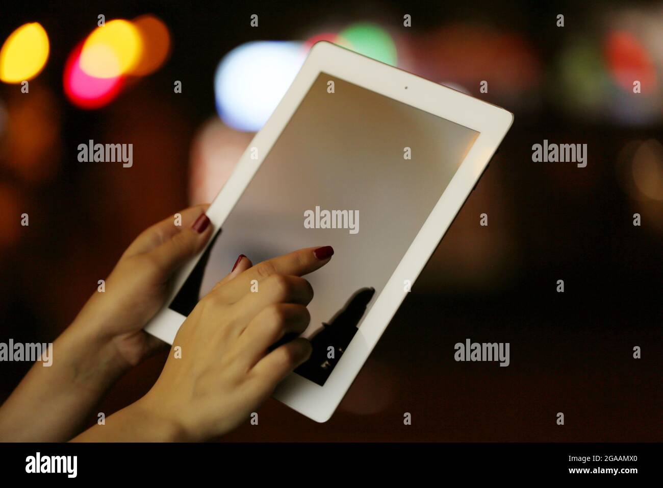 Female hands with tablet on blurred night lights background Stock Photo ...