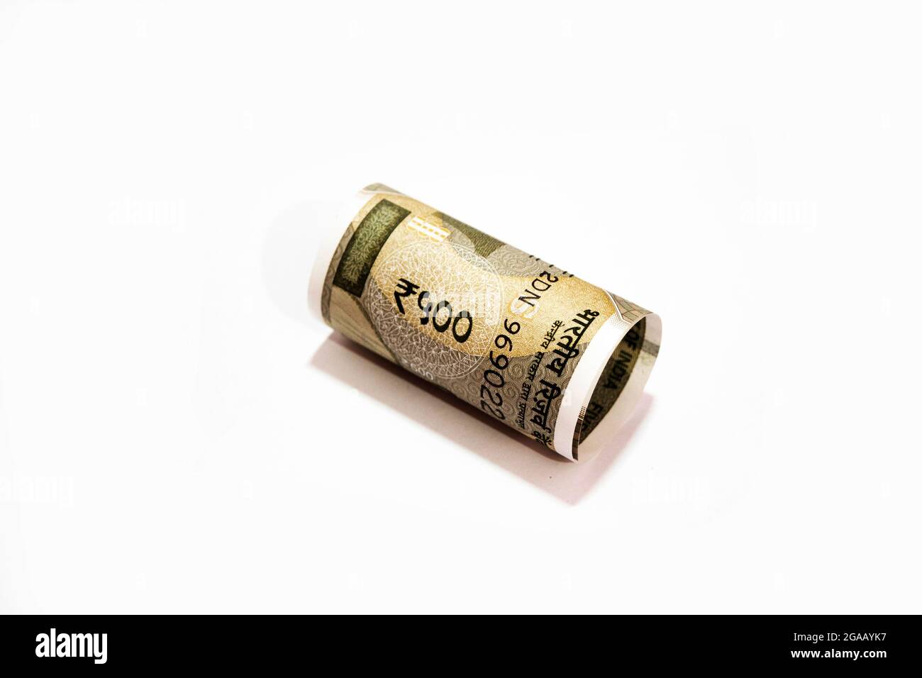 Indian five thousand rupees rolled up banknote isolated on white ...