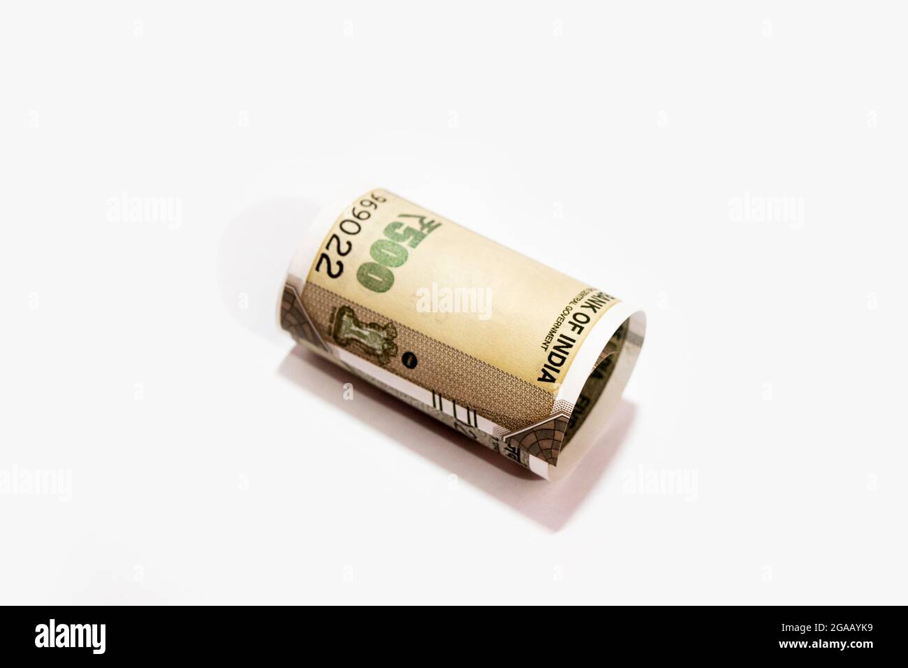 Indian five thousand rupees rolled up banknote isolated on white ...