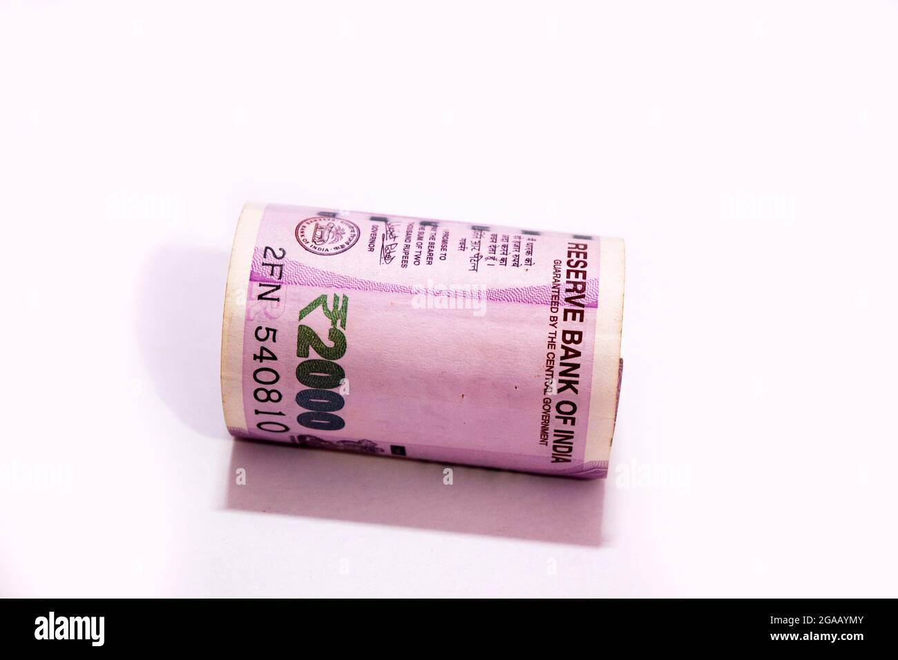 Indian two thousand rupees rolled up banknote isolated on white ...