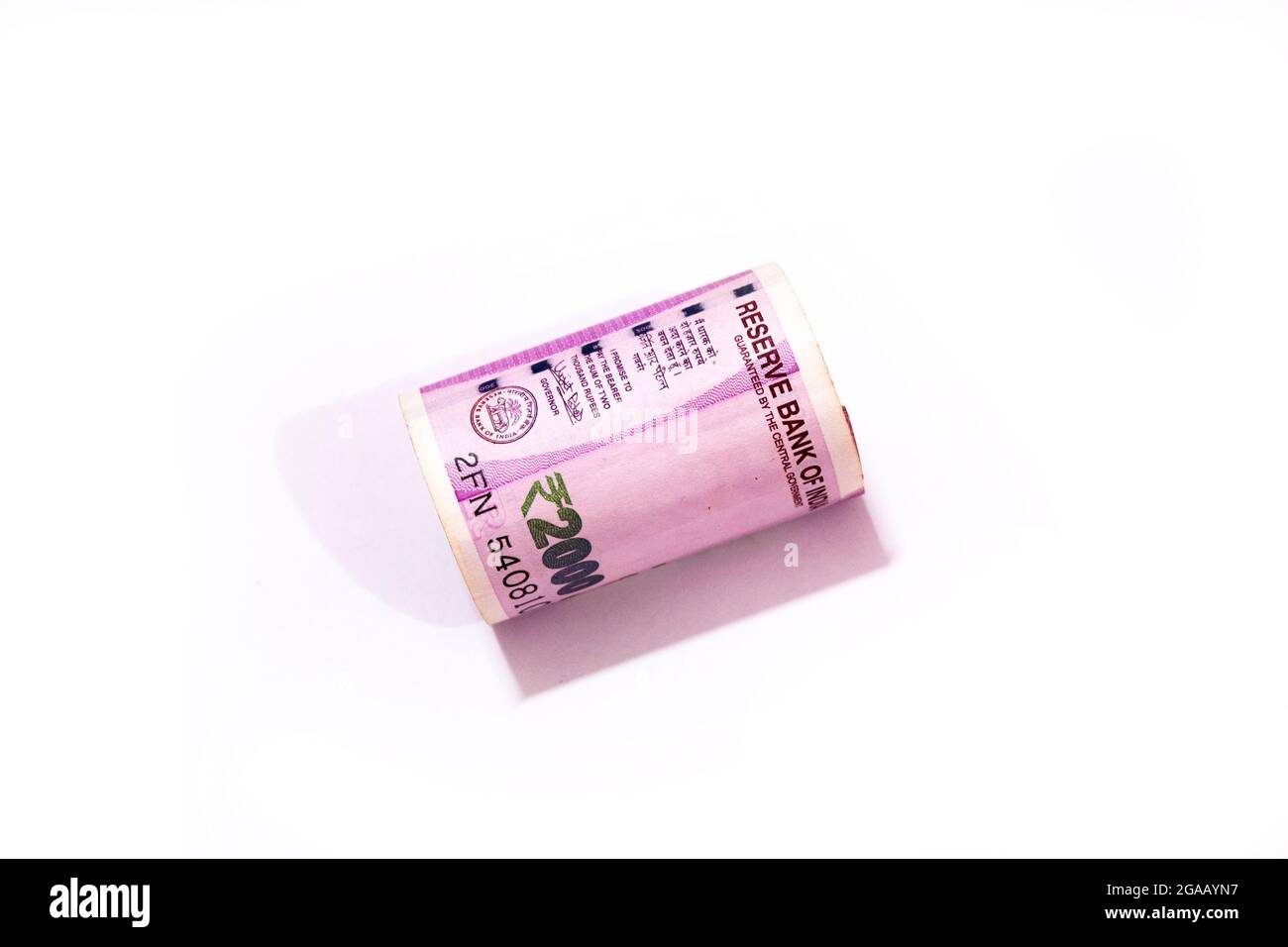 Indian two thousand rupees rolled up banknote isolated on white ...