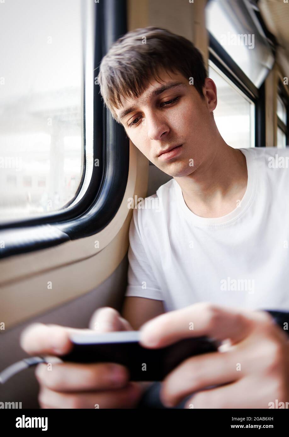 Young Man with Mobile Phone in the Train by the Window Stock Photo - Alamy