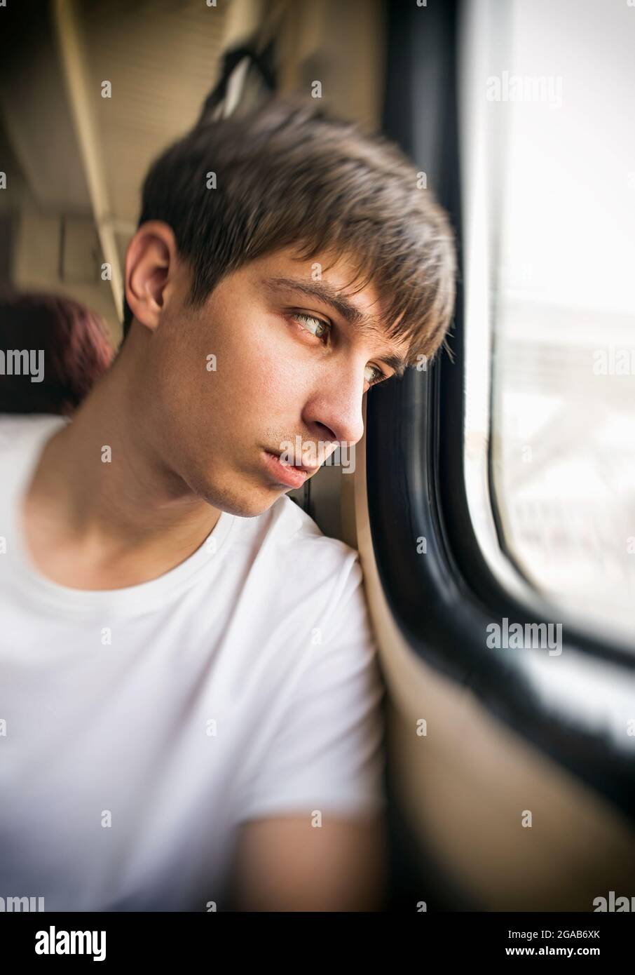 Sad Young Man sit in the Train by the Window Stock Photo - Alamy