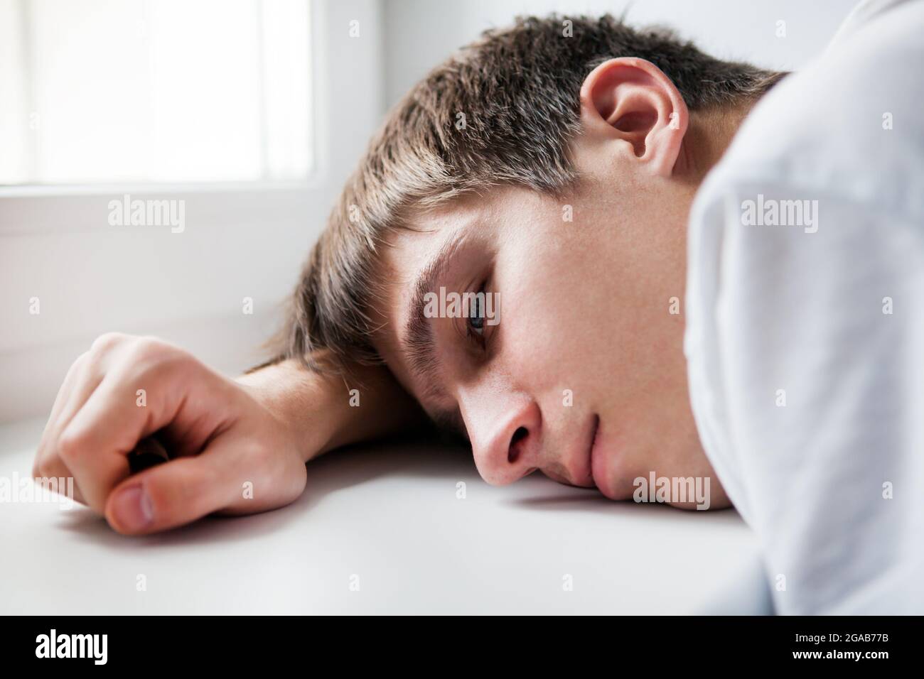Sad Young Man by the Window in the Room Stock Photo - Alamy