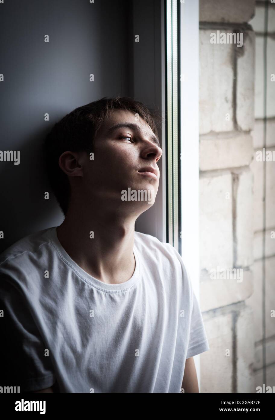 Sad Young Man by the Window in the Room Stock Photo - Alamy