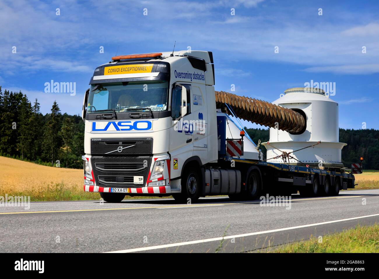 Exceptional load of industrial equipment by white Volvo FH semi trailer ...