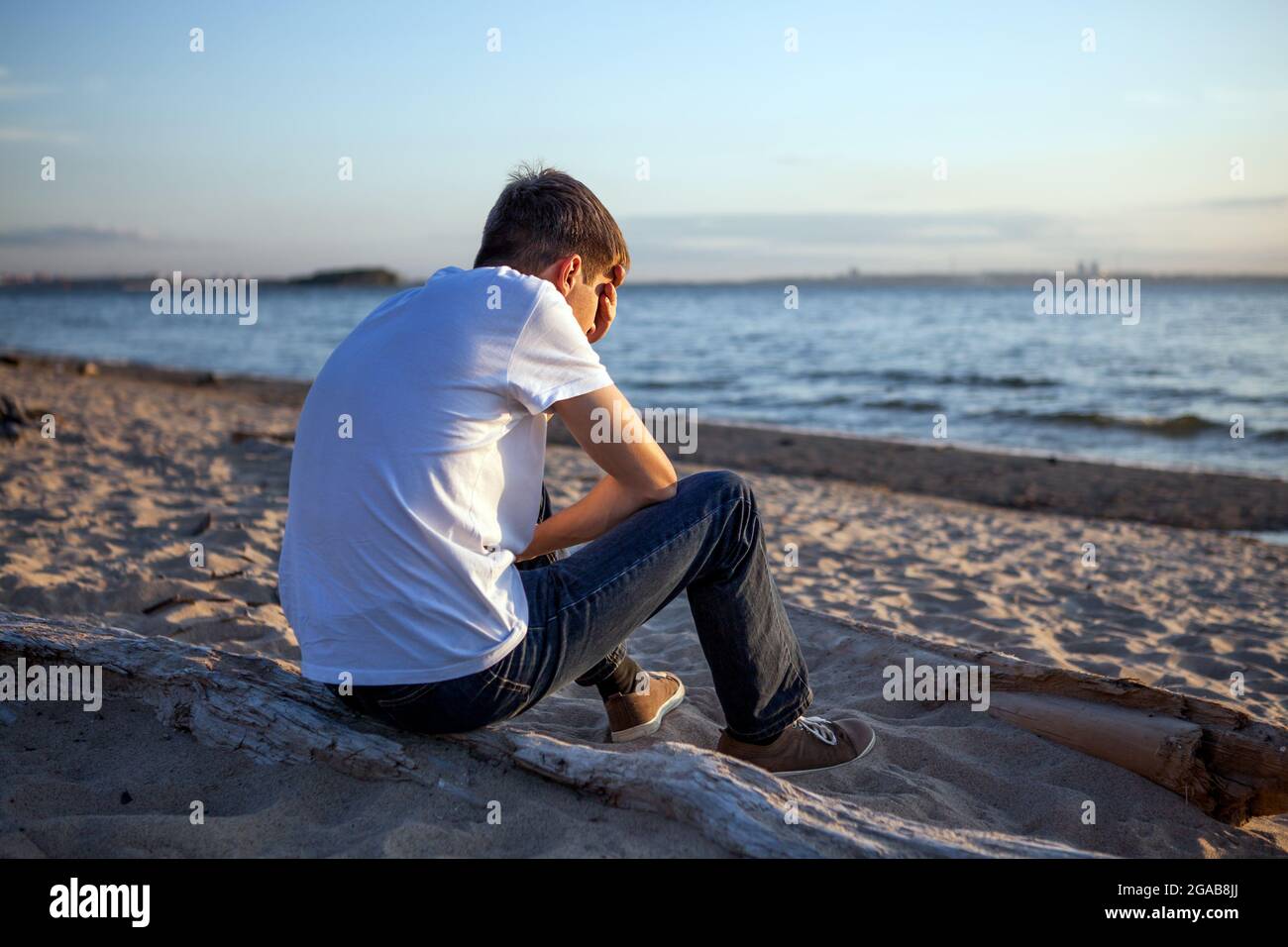 Sad and Lonely Young Man sit at Seaside Stock Photo - Alamy