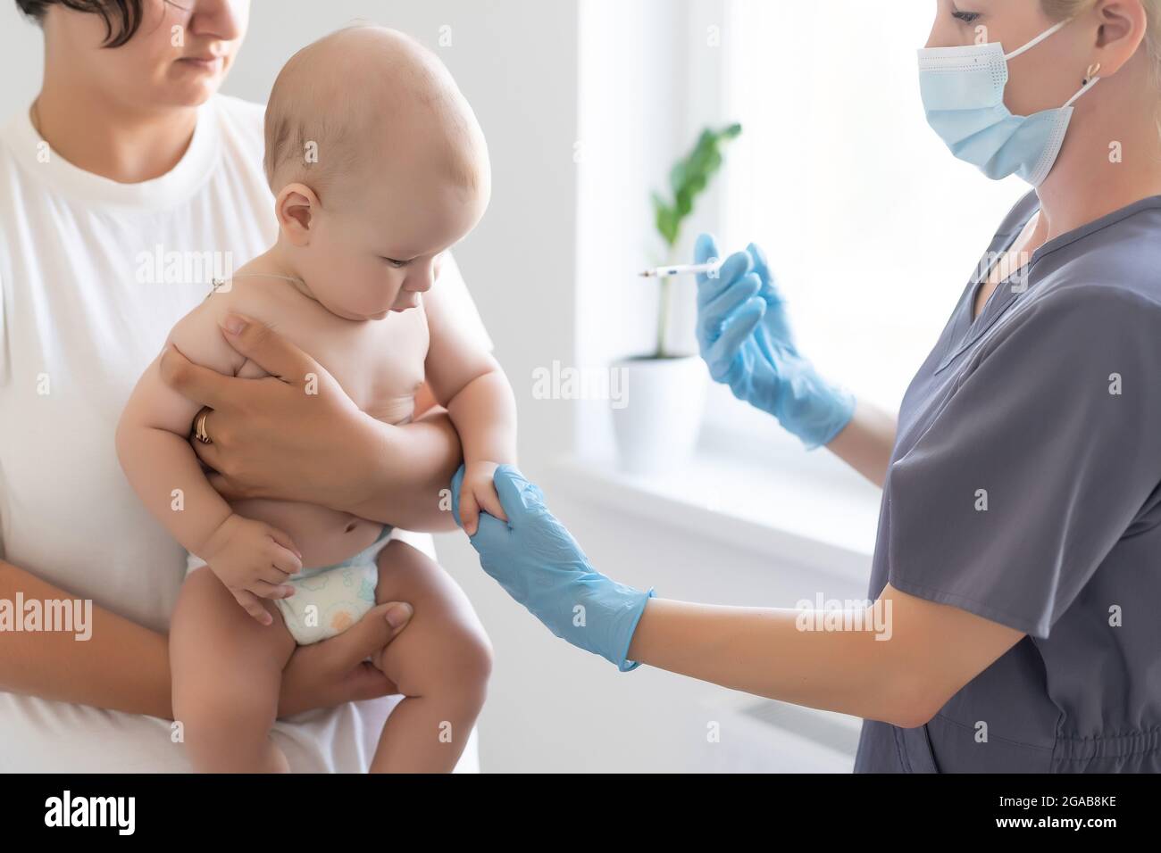 Pediatrician doctor with syringe, tense mother and baby Stock Photo - Alamy
