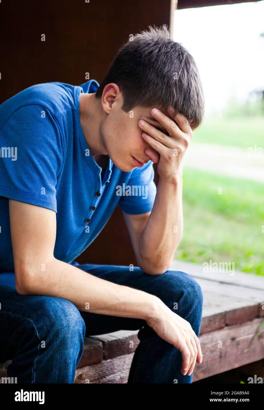 Sad Young Man sit near the House outdoor Stock Photo - Alamy