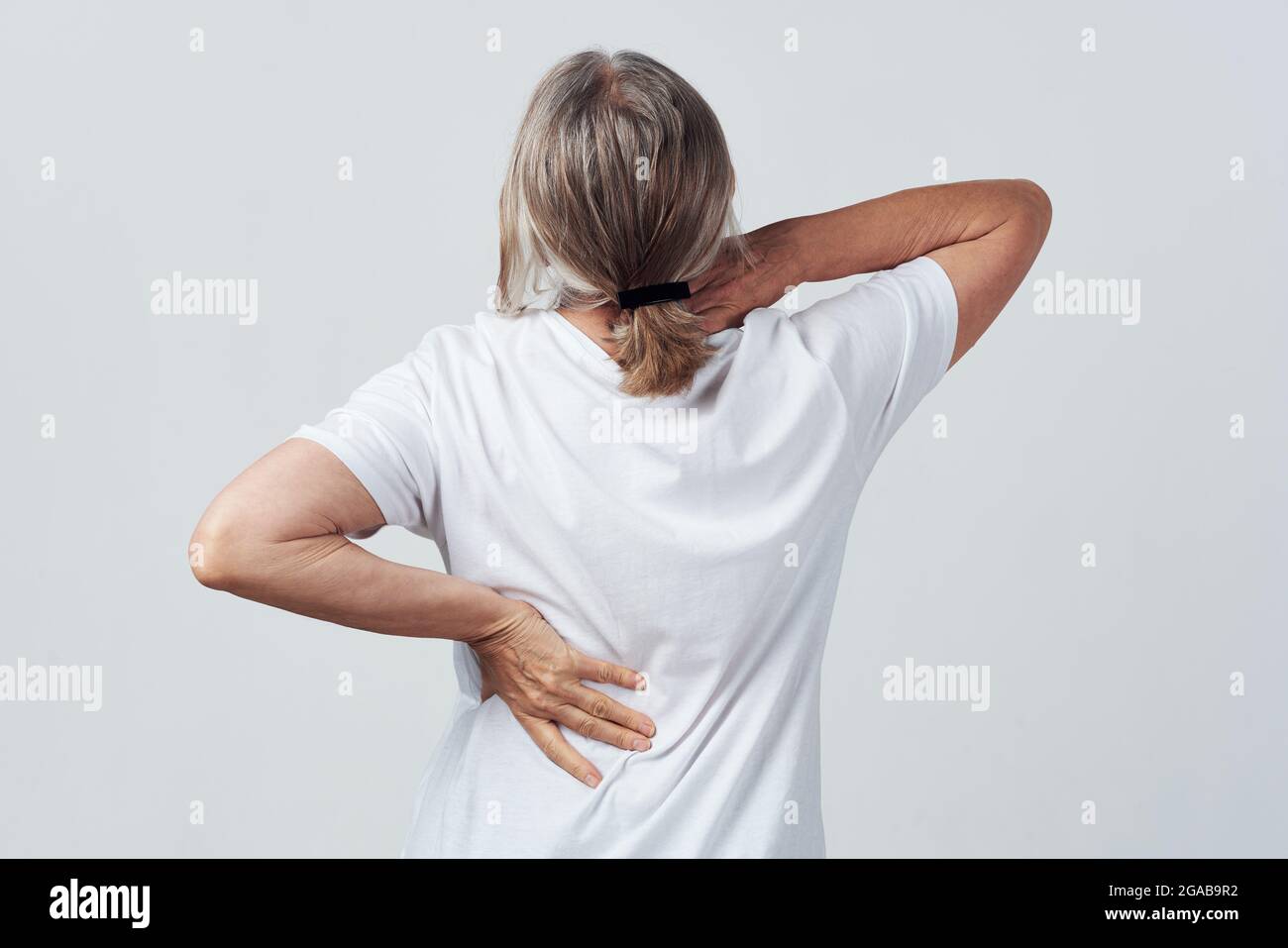 elderly woman back pain back view health problems Stock Photo - Alamy