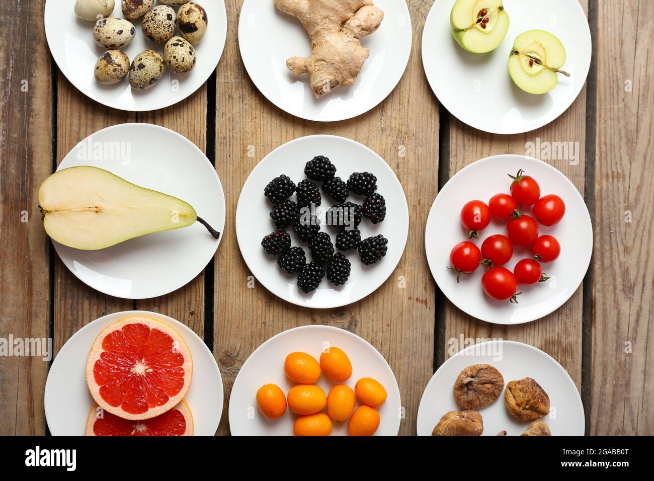 Different products on saucers on wooden table, top view Stock Photo - Alamy