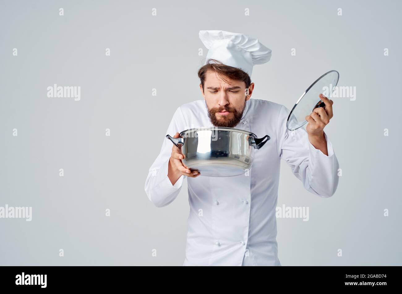 professional chef with pan in hand cooking food kitchen light ...