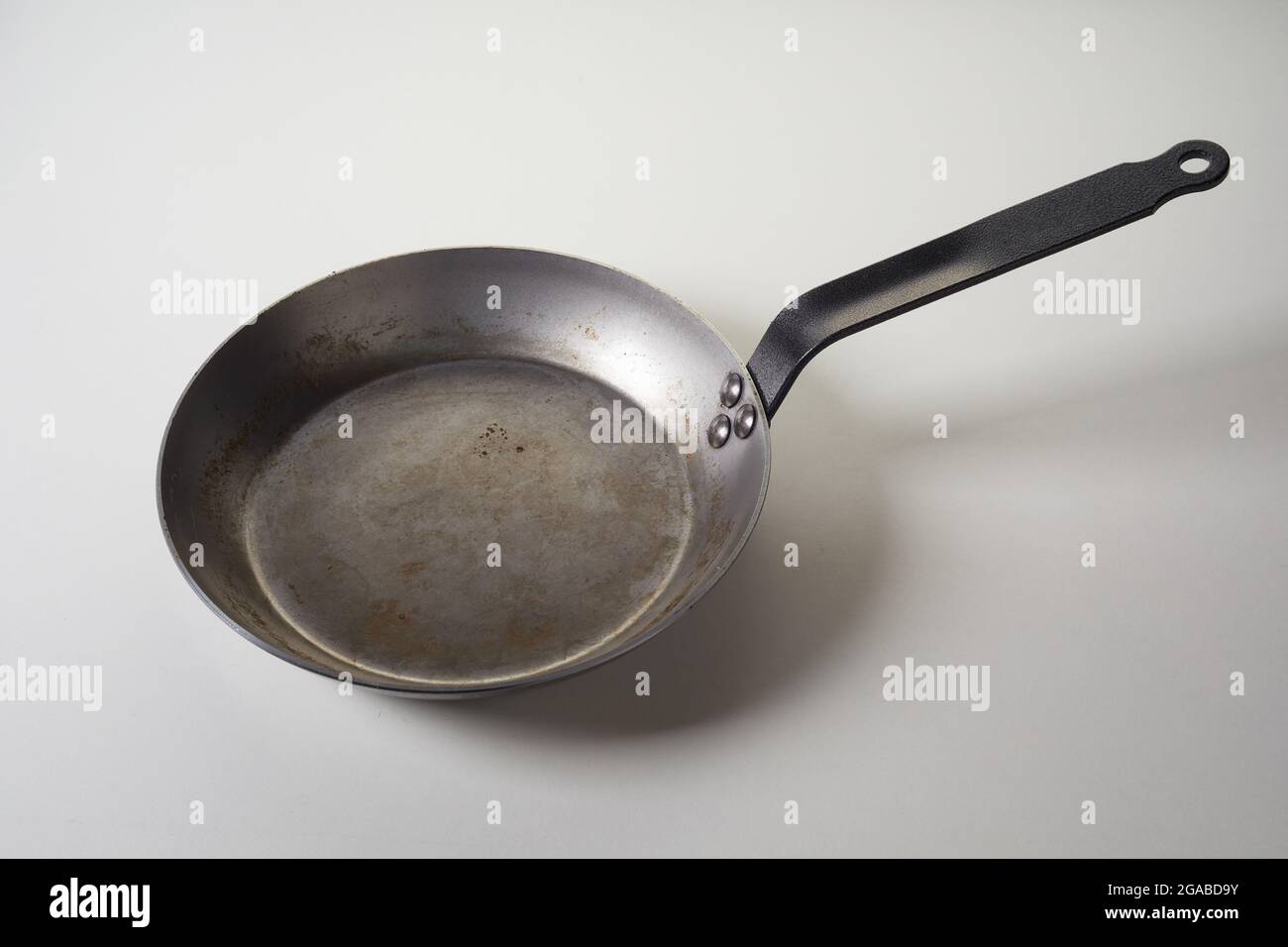 High angle of empty frying pan made of stained steel placed on gray ...