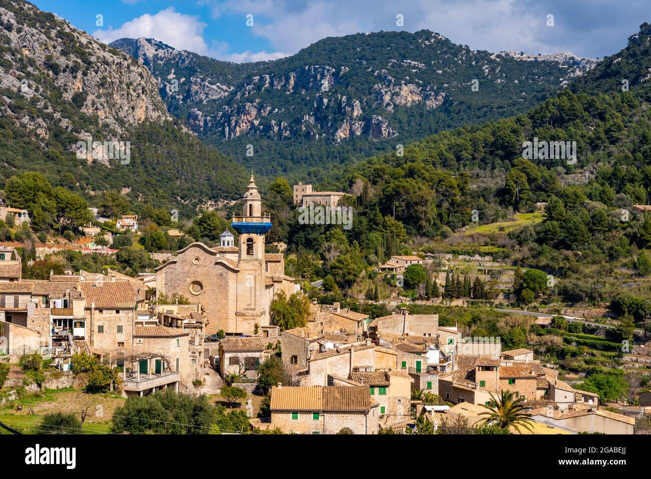 View of Monastery Valldemossa with green mountains under blue sky in ...
