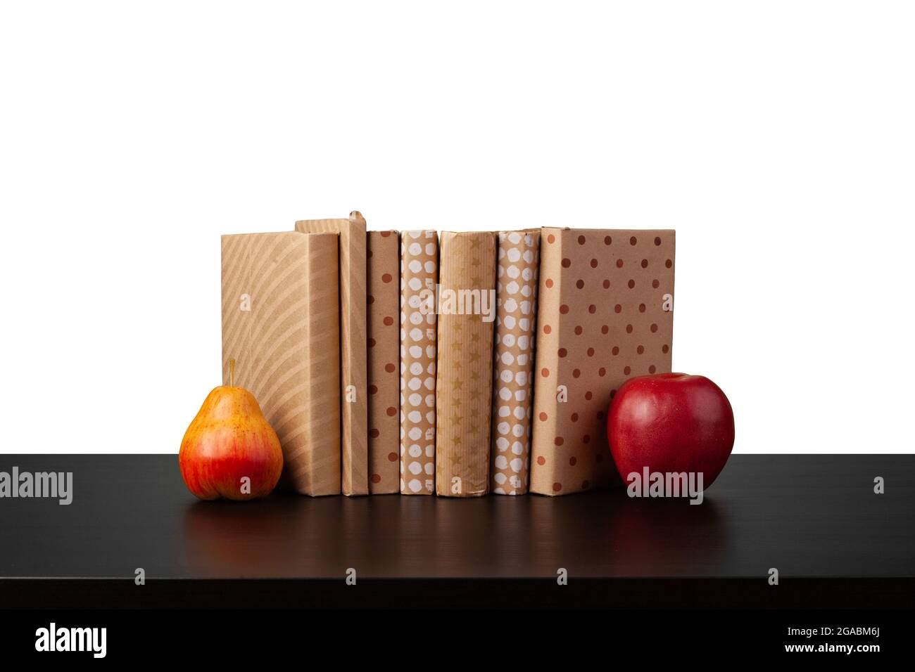 Stack of books and apple on tabletop against white background Stock ...