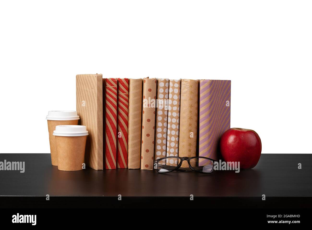 Stack of books and apple on tabletop against white background Stock ...