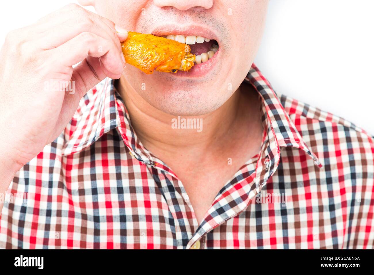 Man eating roasted chicken wings on white background Stock Photo - Alamy