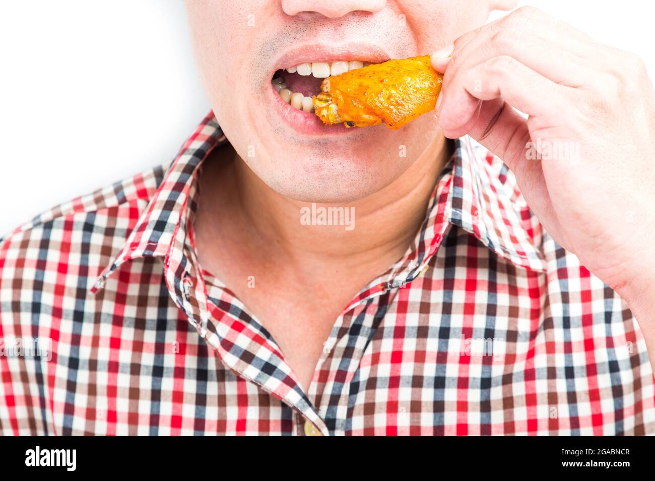 Man eating roasted chicken wings on white background Stock Photo - Alamy