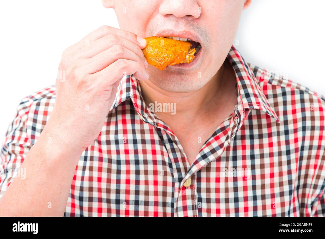 Man eating roasted chicken wings on white background Stock Photo - Alamy