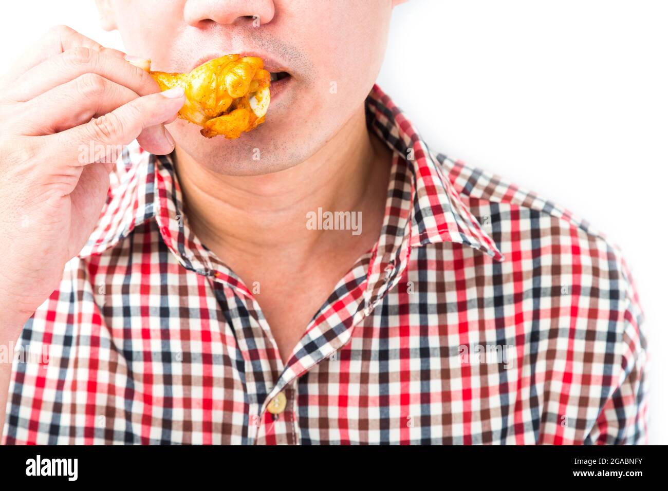 Man eating roasted chicken wings on white background Stock Photo - Alamy