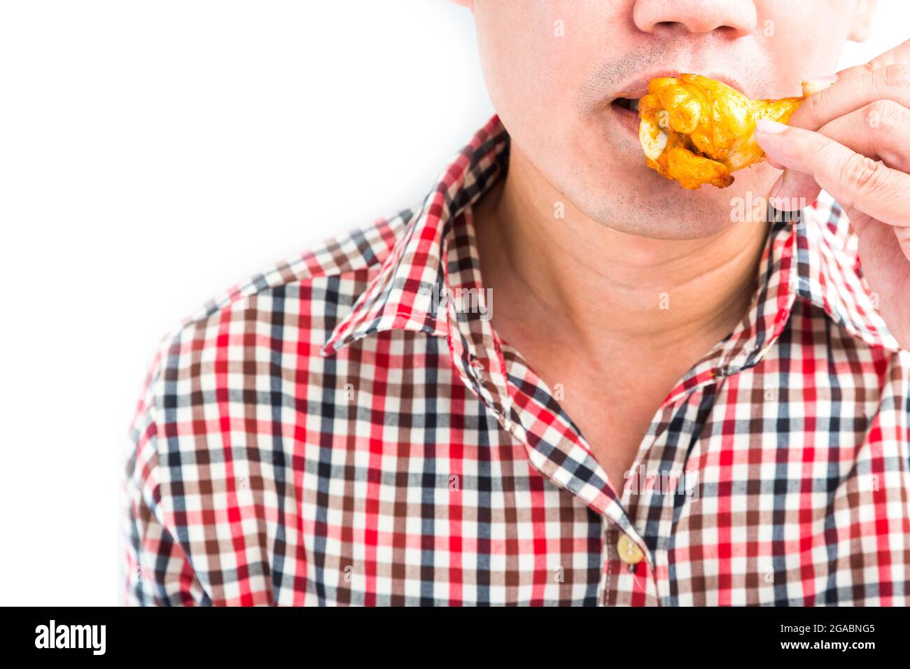Man eating roasted chicken wings on white background Stock Photo - Alamy