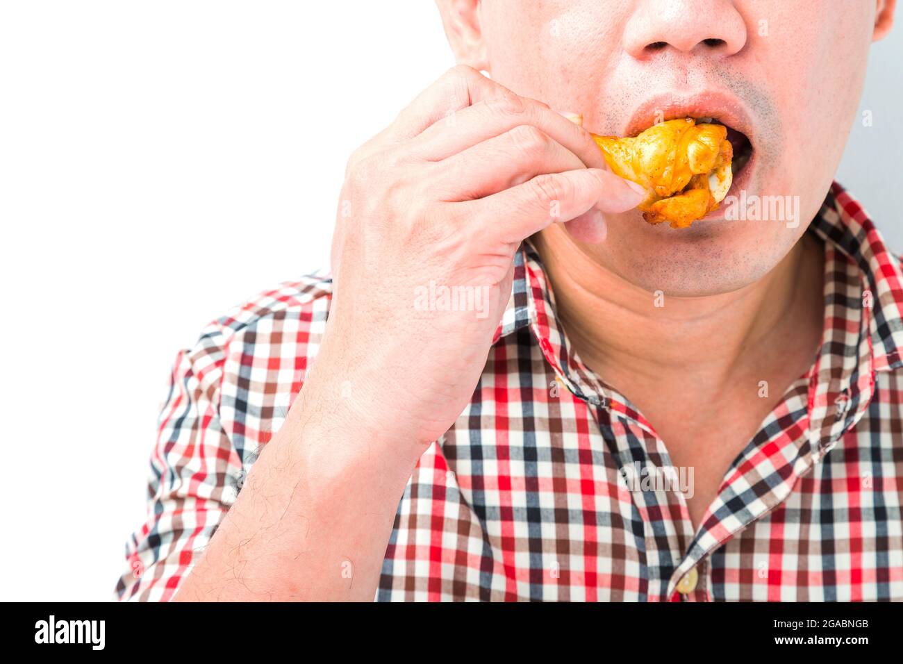 Man eating roasted chicken wings on white background Stock Photo - Alamy