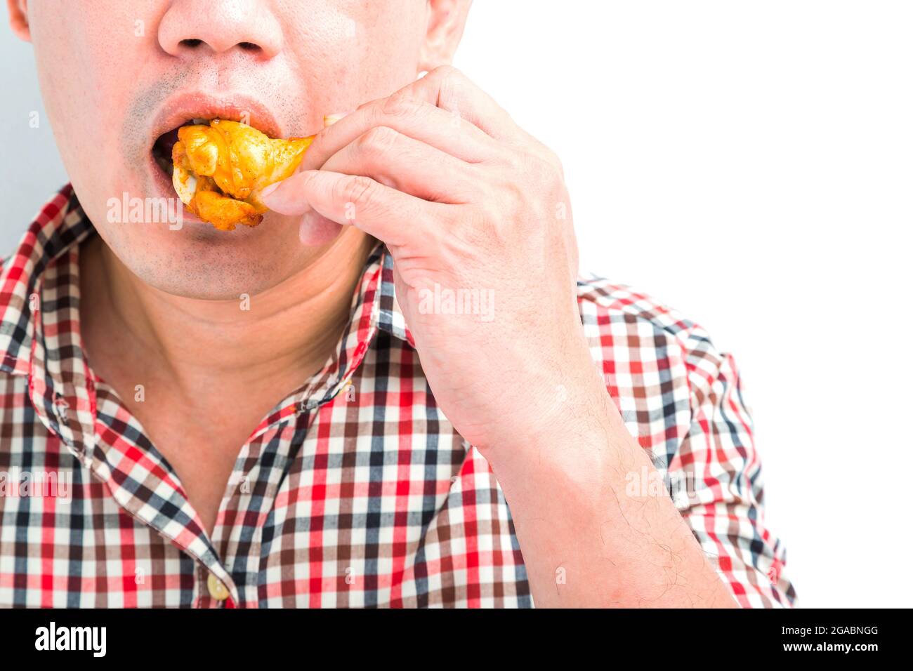 Man eating roasted chicken wings on white background Stock Photo - Alamy