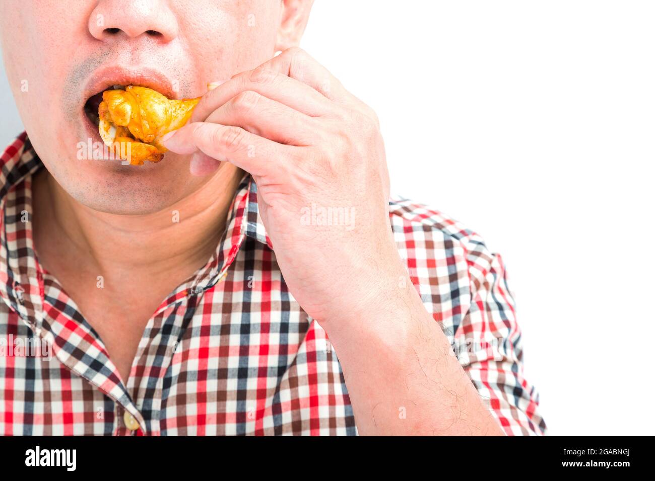 Man eating roasted chicken wings on white background Stock Photo - Alamy