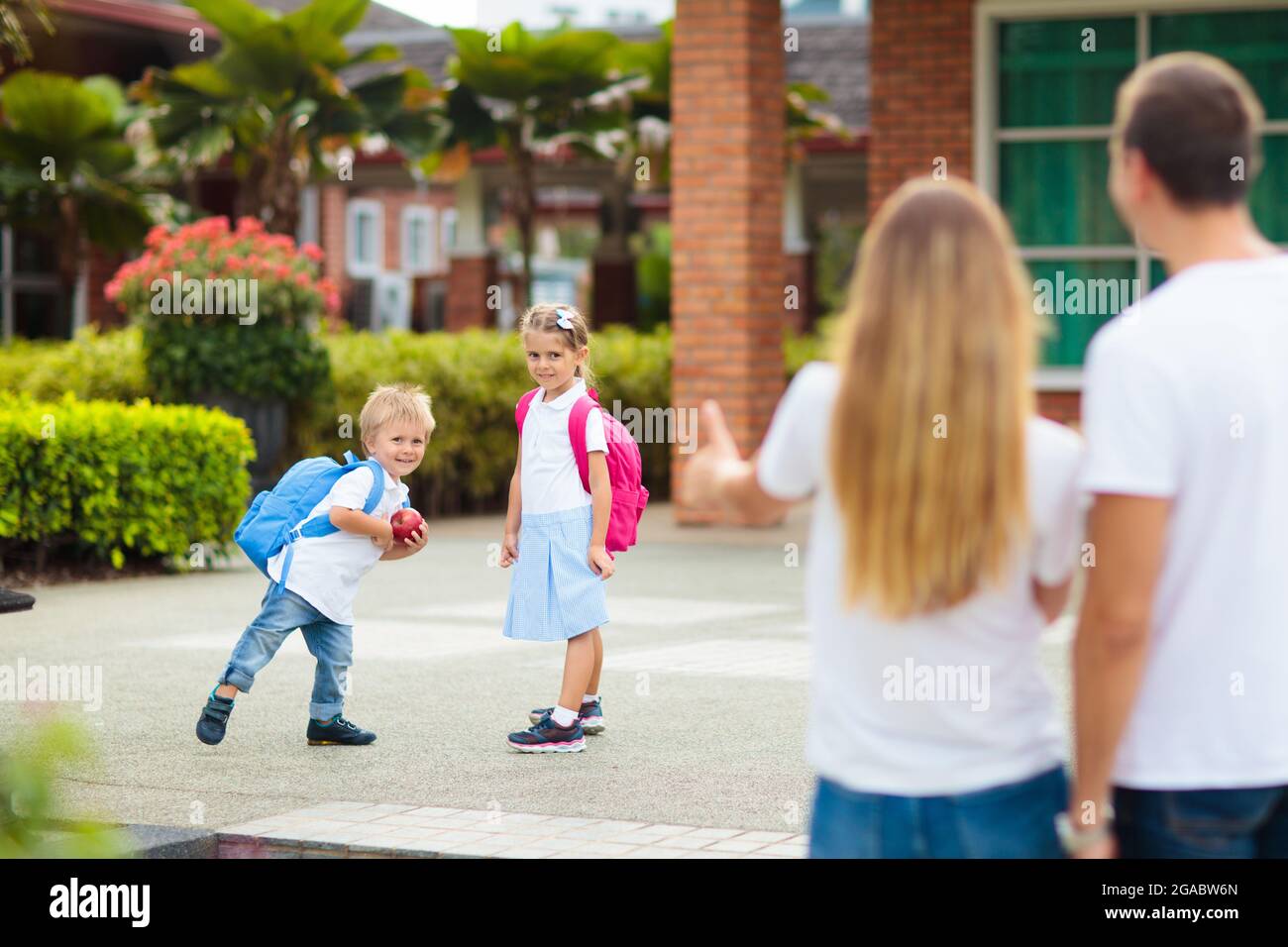 Mother and kids after school. Young mom picking up children after ...