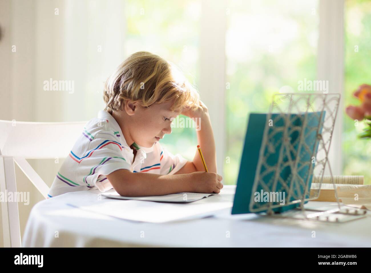 Child studying from home doing homework. Online remote learning. School ...